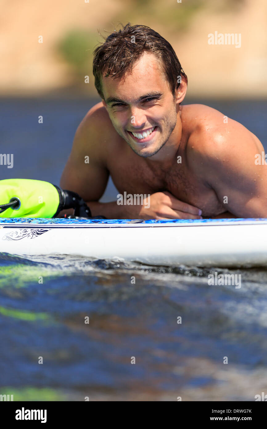 Happy windsurfer take a rest on the board and smiling Stock Photo - Alamy