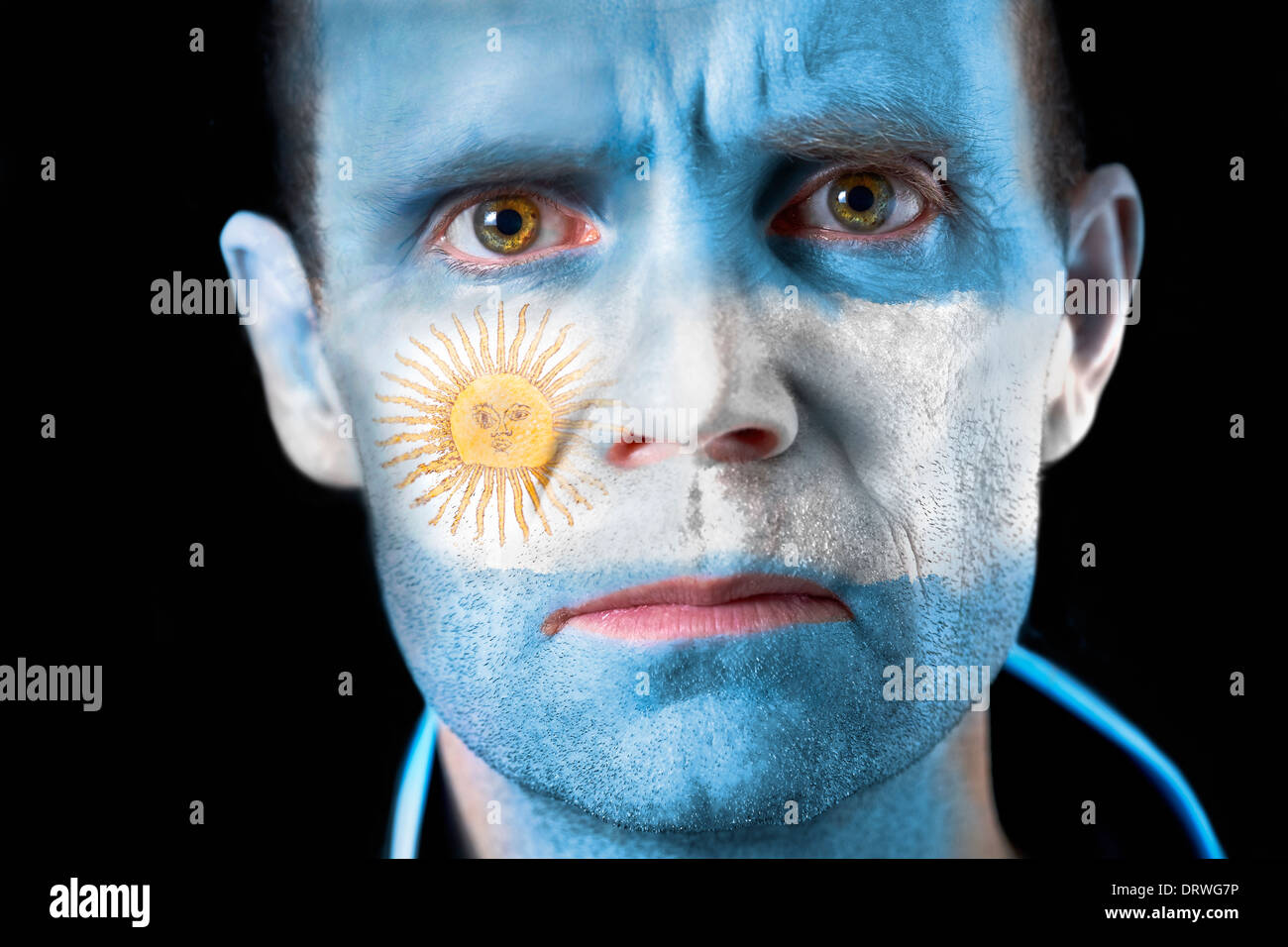 An intense stare from a football fan with their face painted with the ...