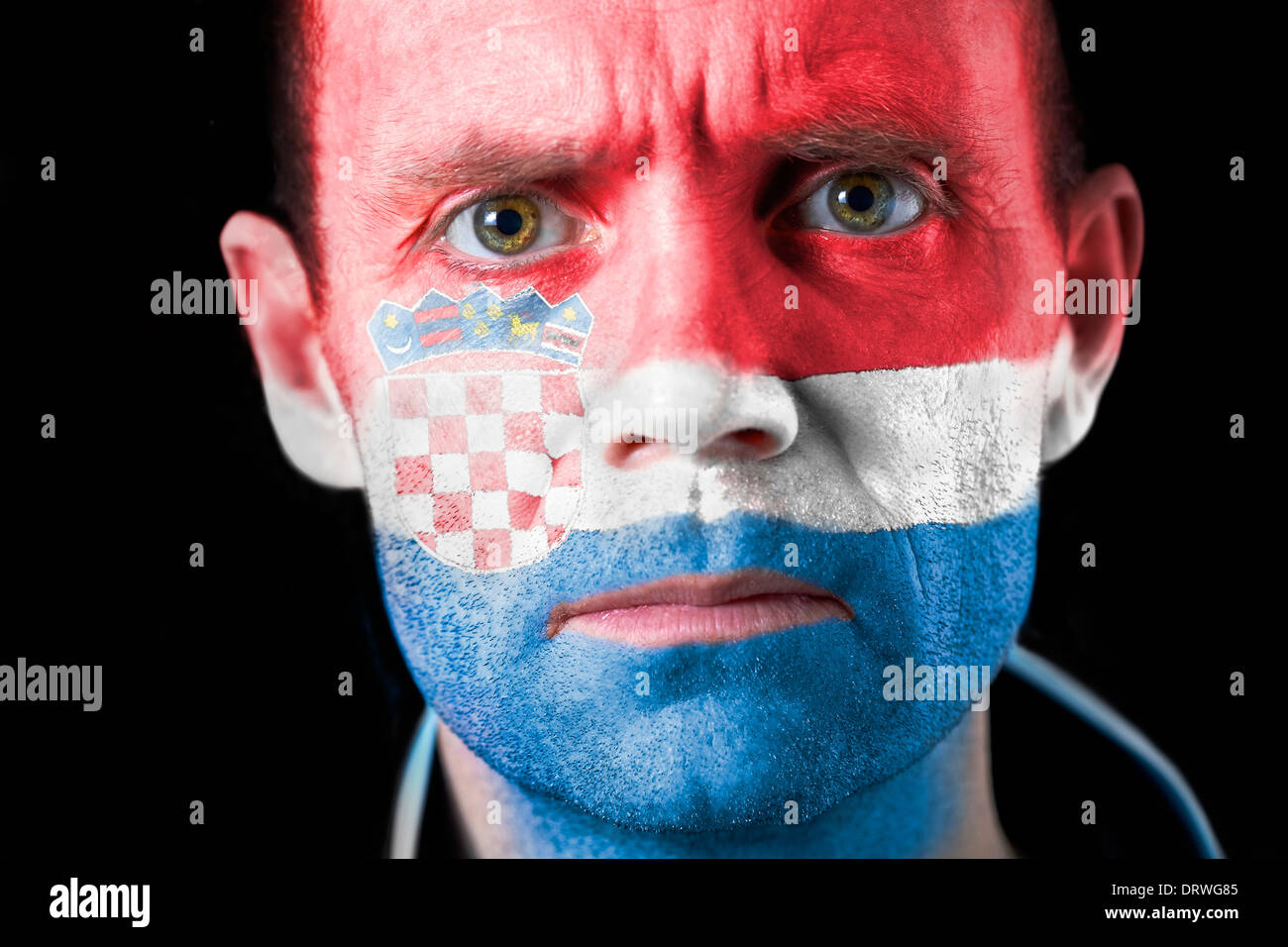 An intense stare from a football fan with their face painted with the ...