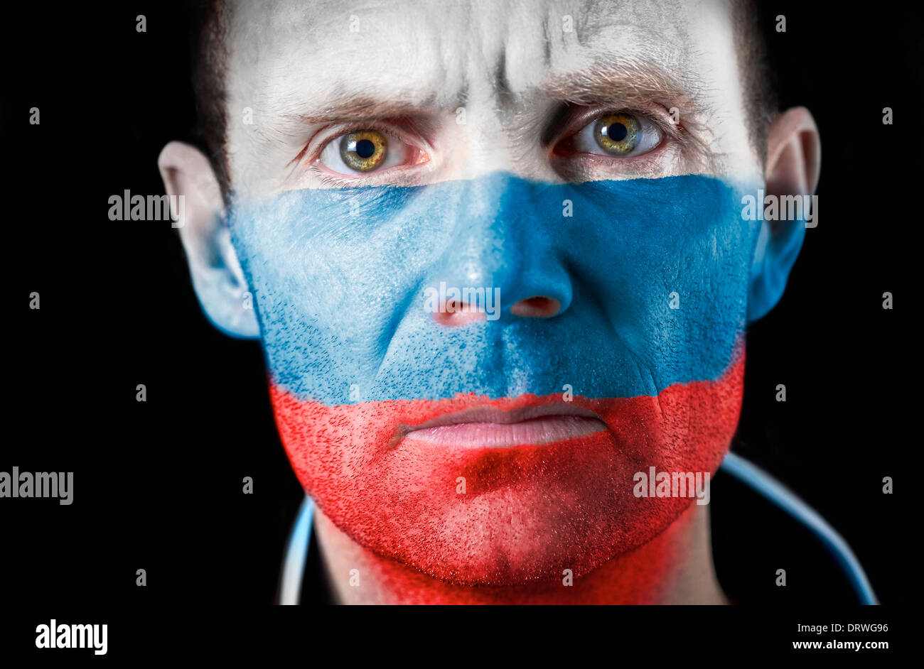 An intense stare from a football fan with their face painted with the ...