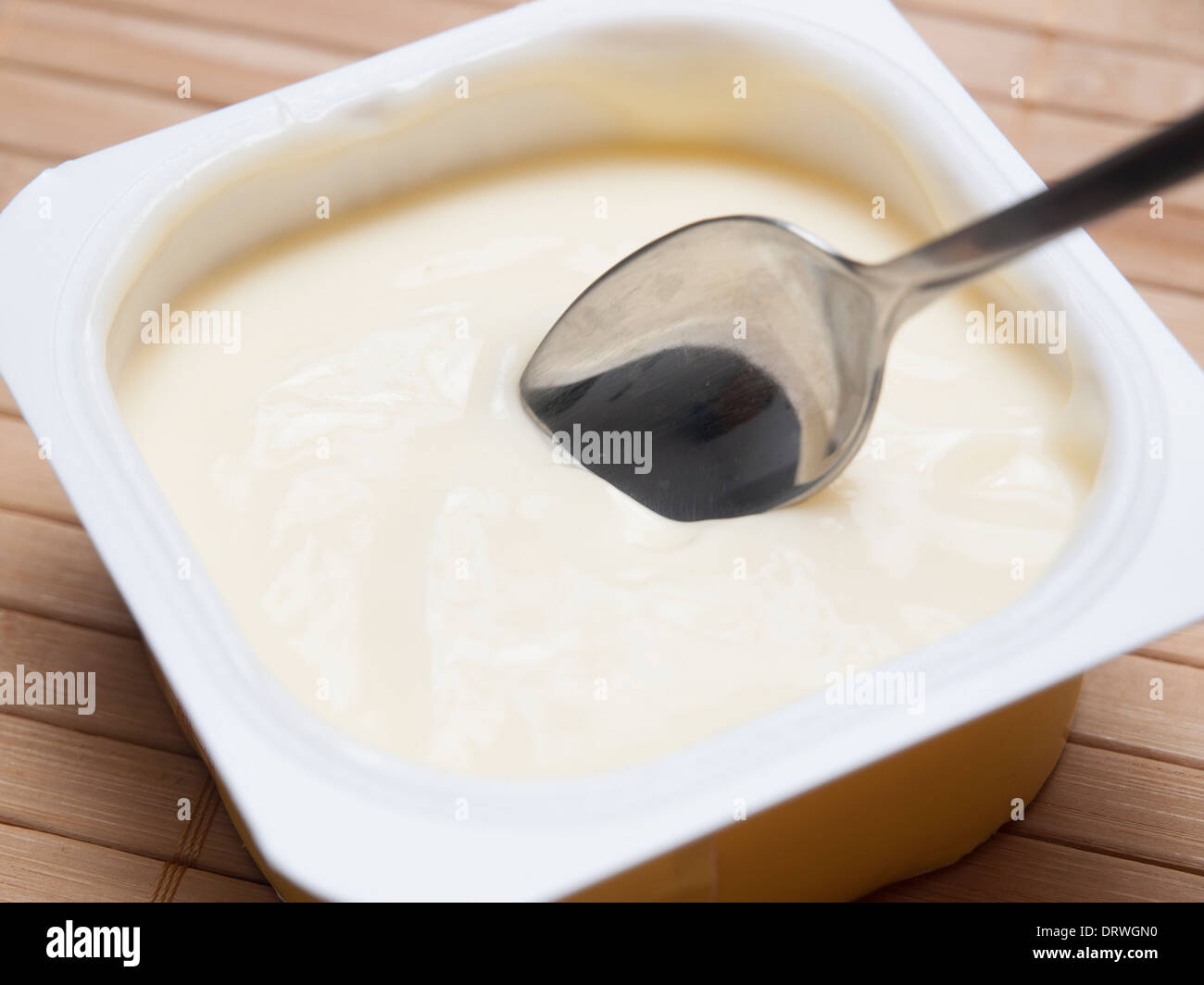 Spoon and custard detail in a studio shot in horizontal composition ...