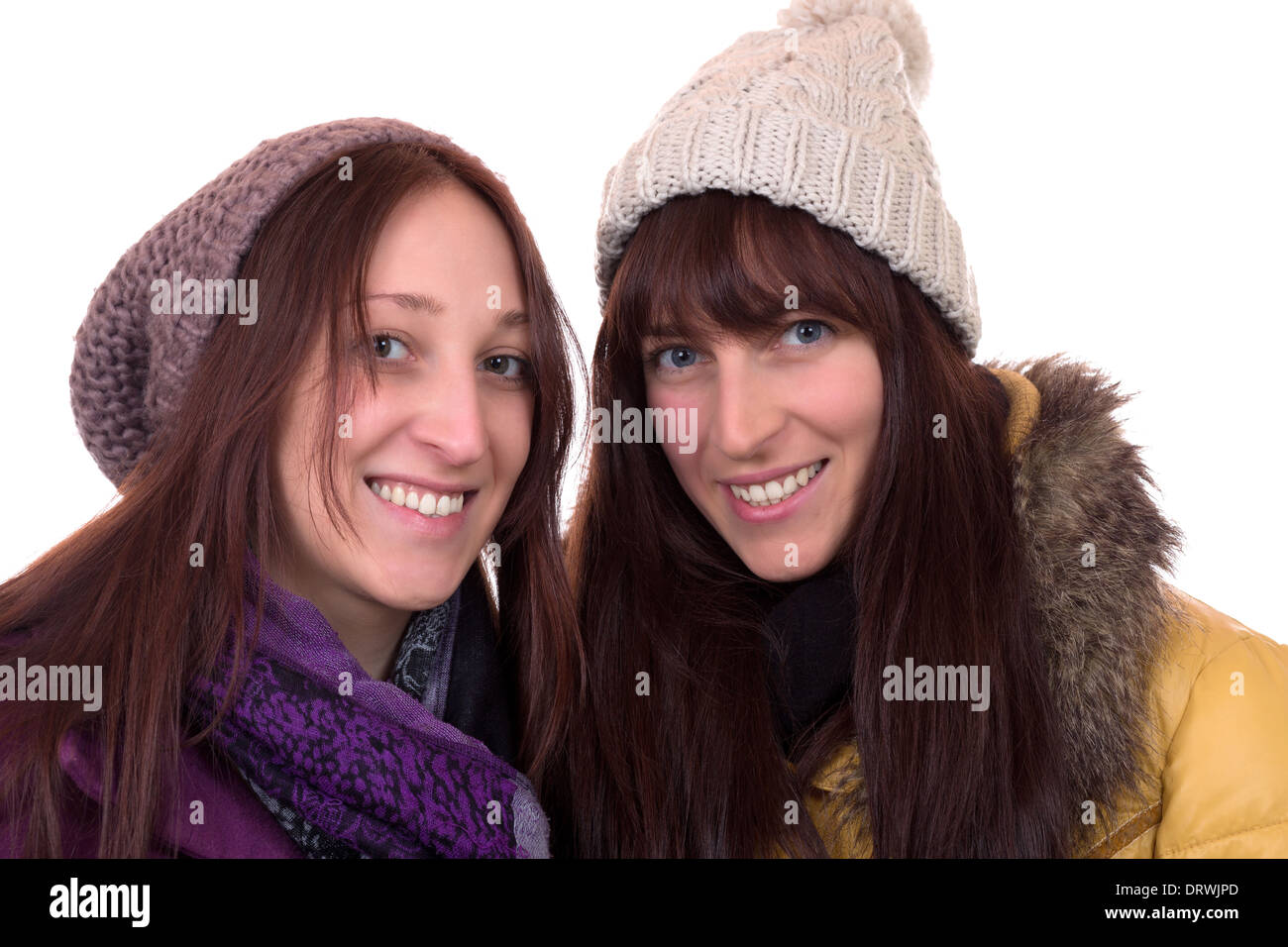Two young women in winter with scarf and caps, isolated on a white ...