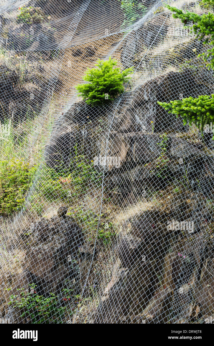 Wire mesh used to prevent rockfalls on a steep roadside bank. Bingen ...