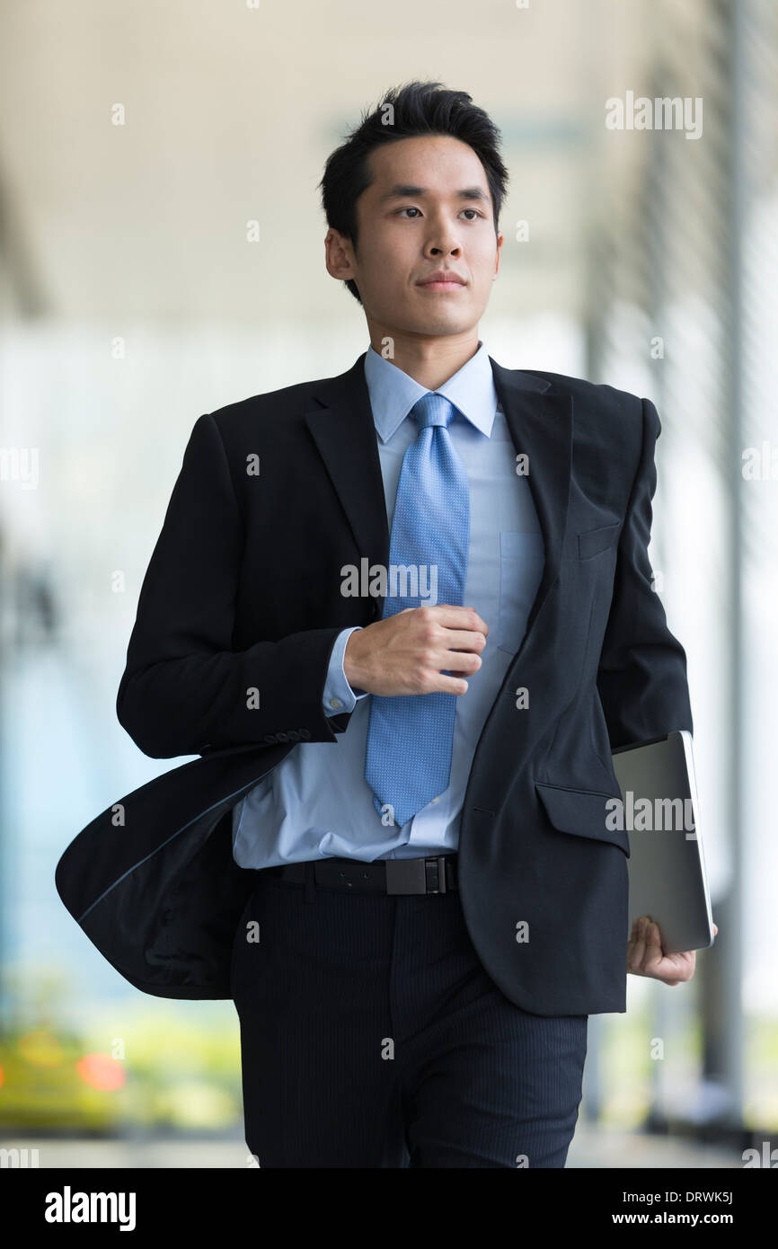 Young Chinese businessman running in a modern city street Stock Photo ...