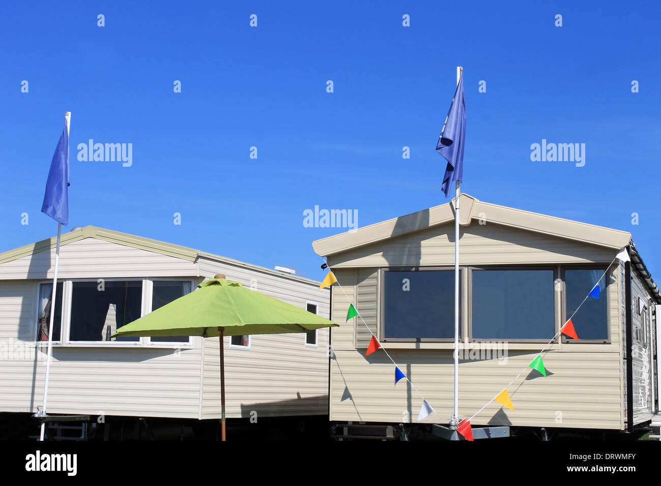 Exterior of two new caravans on trailer park with blue sky background ...