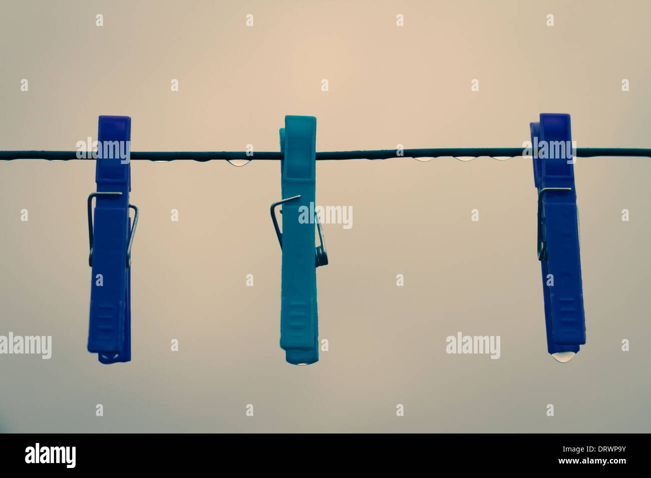 Three clothes pegs on washing line Stock Photo - Alamy