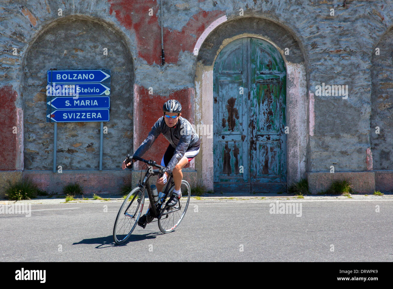 Cyclist riding British Scott bike passes signpost on The Stelvio Pass ...