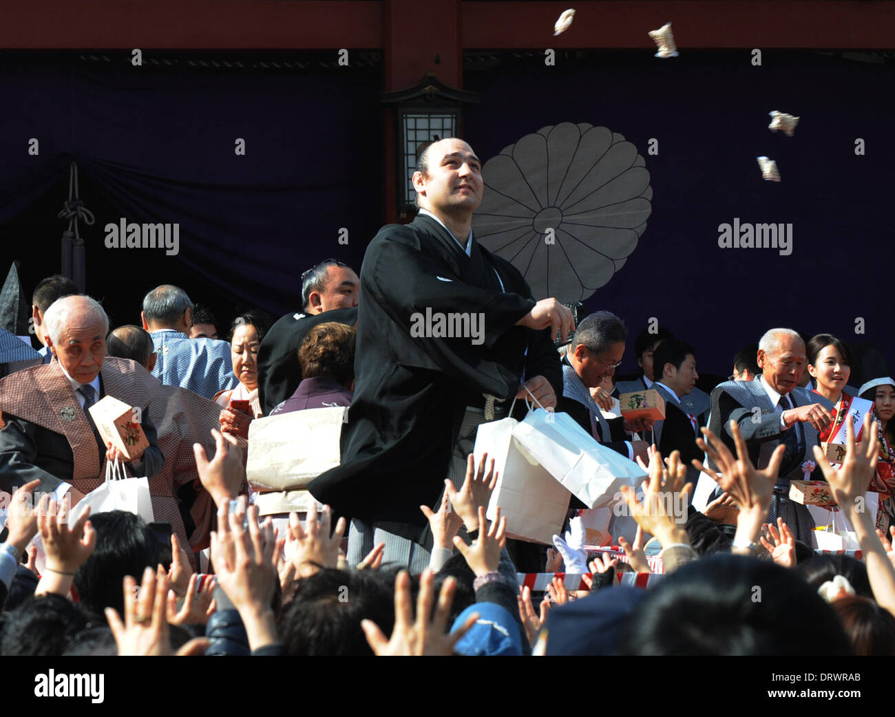 Tokyo, Japan. 3rd Feb, 2014. A Sumo wrestler (C) throws bags of beans ...