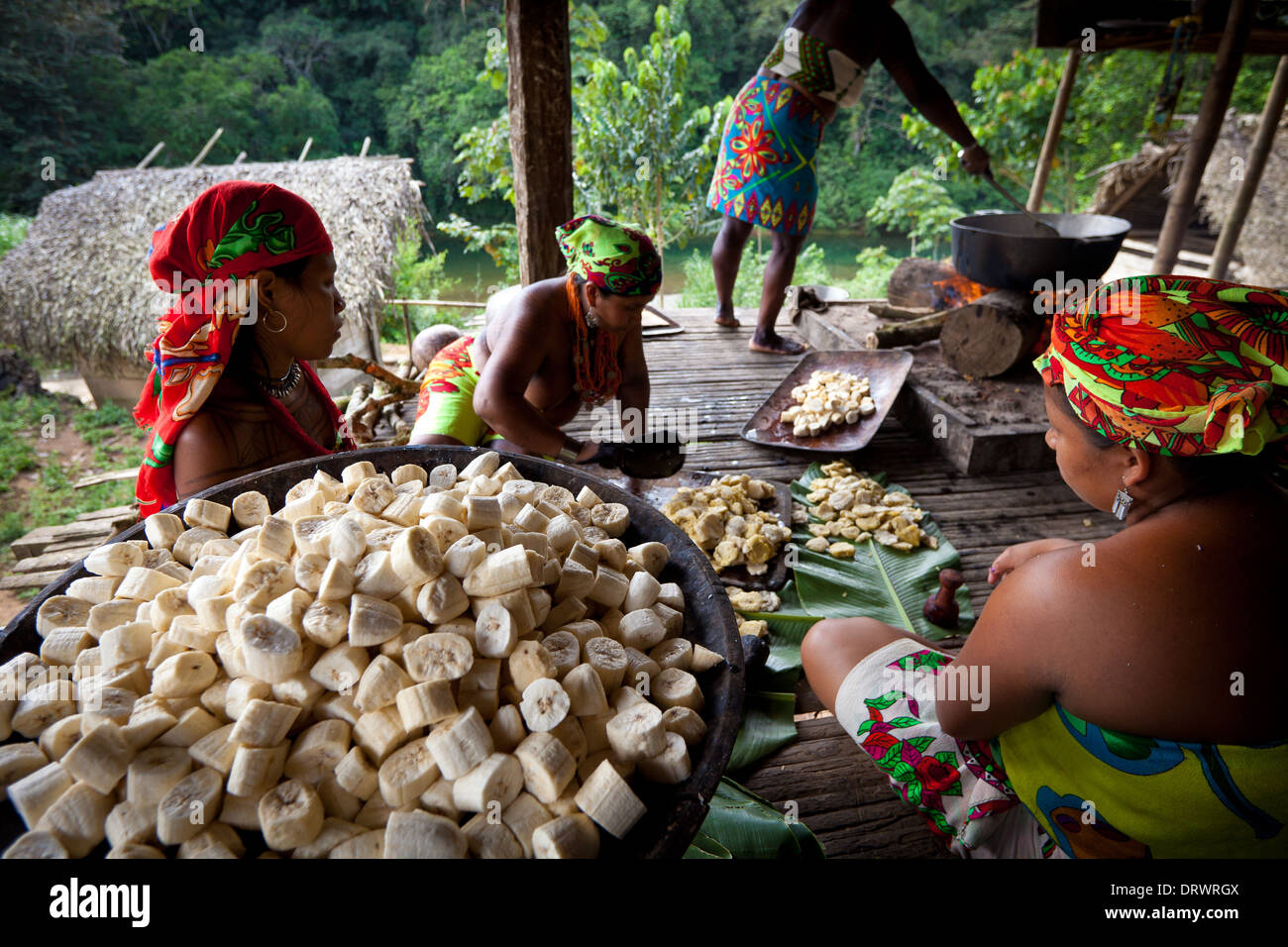 Embera Puru indian woman are preparing and frying plantain, in their ...