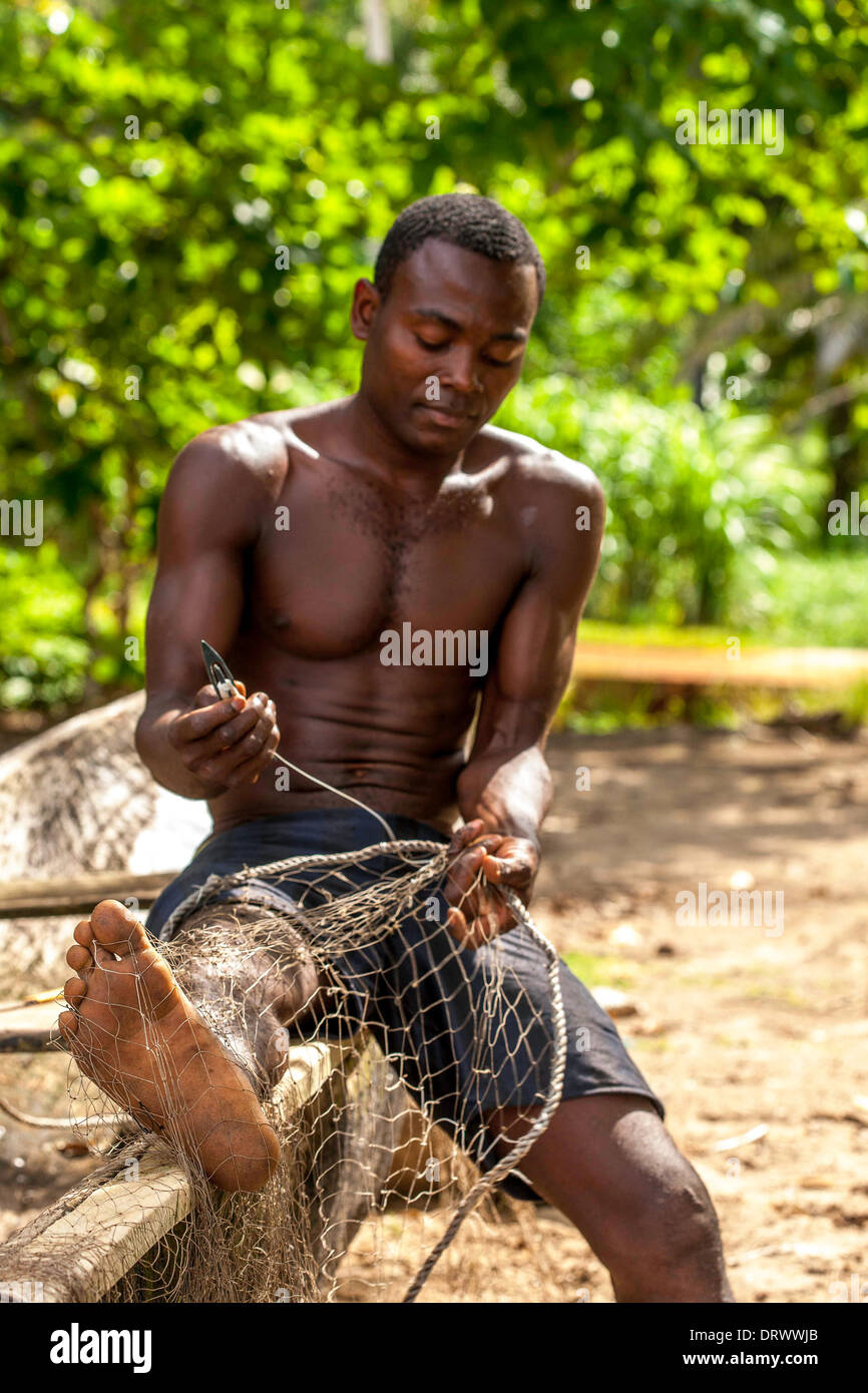 Fisherman repairing fishing net, Principe Island Stock Photo - Alamy