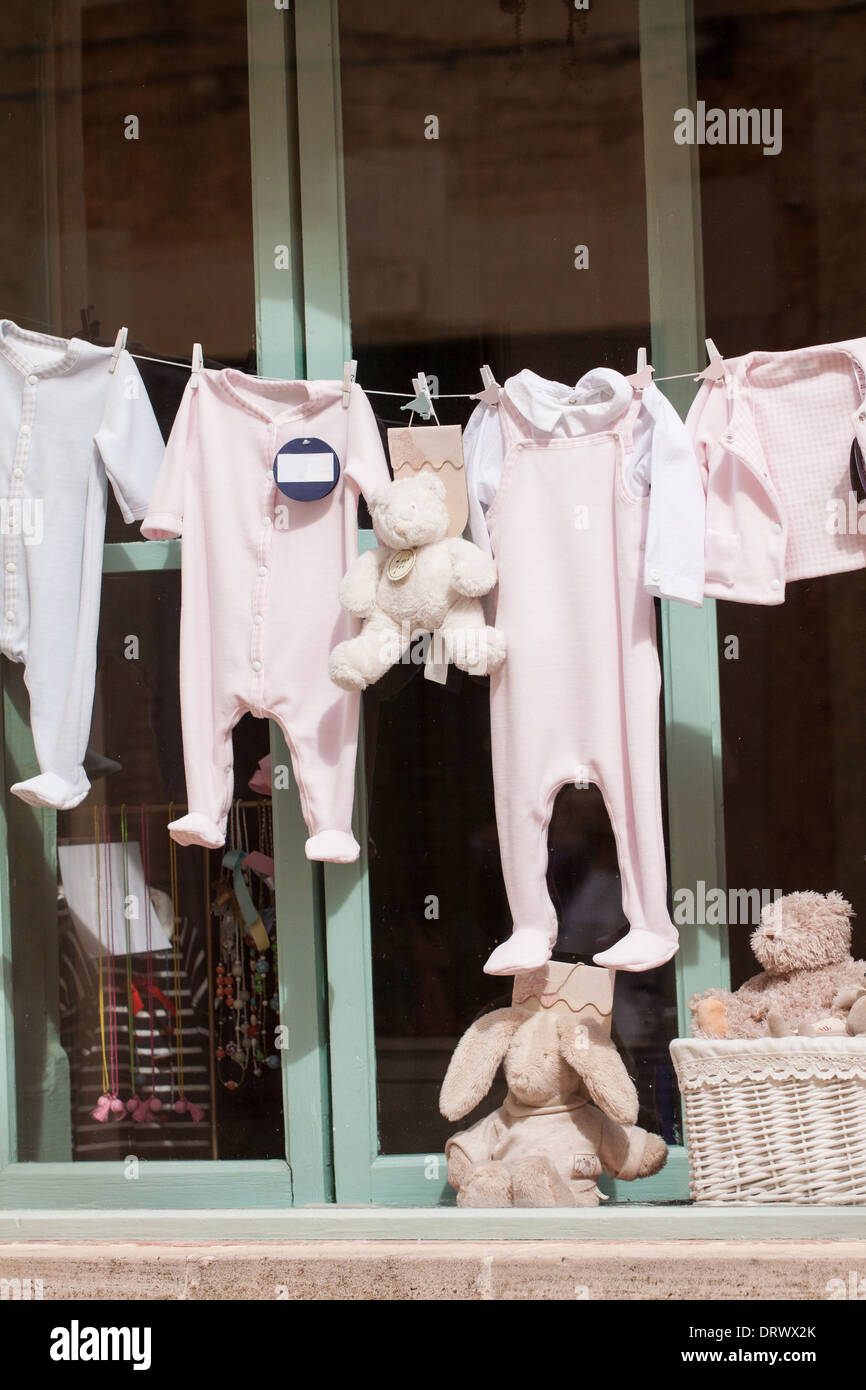 baby clothing and teddy bear in window shopping objects Stock Photo - Alamy