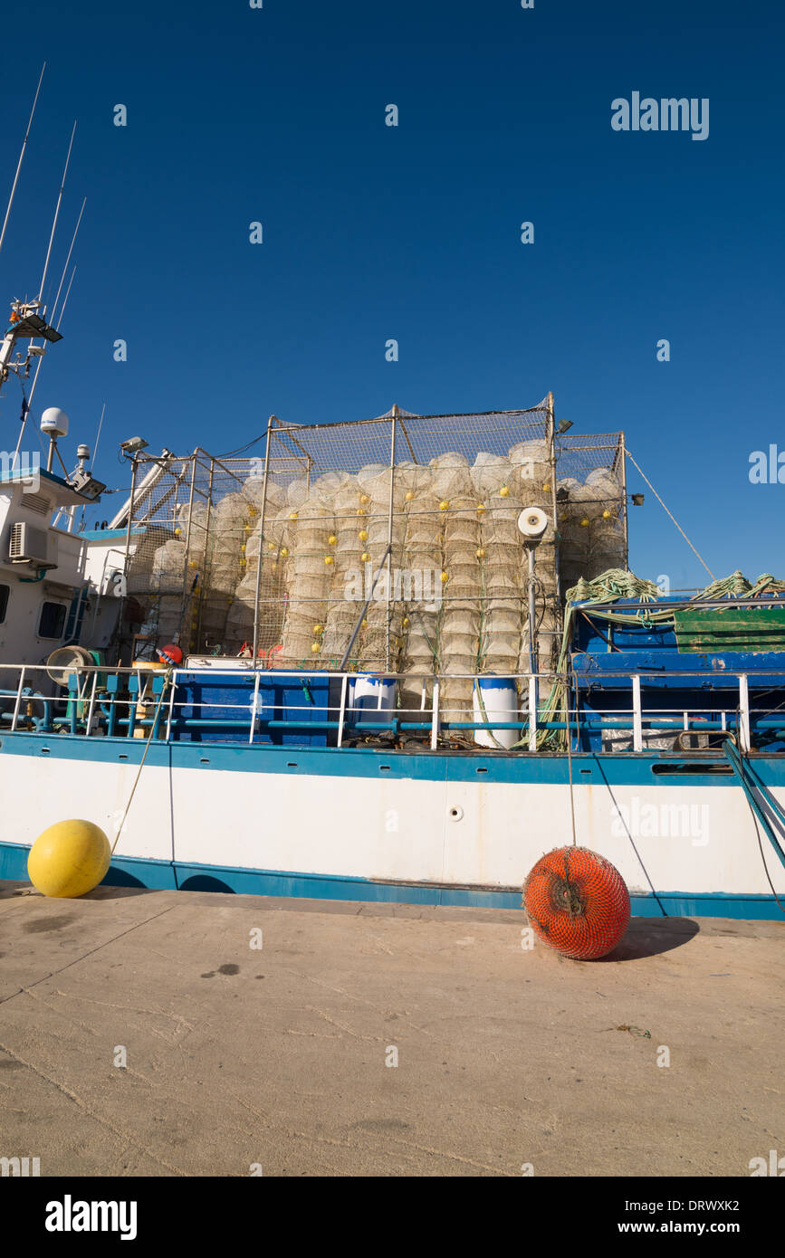 Aquaculture equipment loaded on a trawler moored on a fishing harbor ...