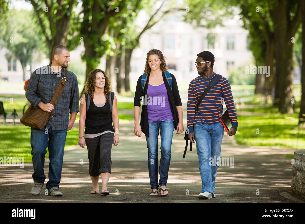 Friends Walking On Campus Road Stock Photo - Alamy