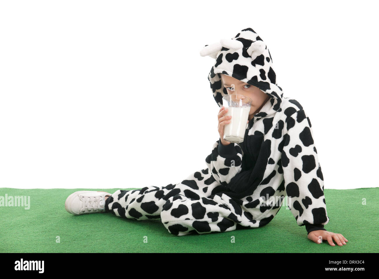Little boy dressed as cow sitting in the grass and drinking milk Stock ...
