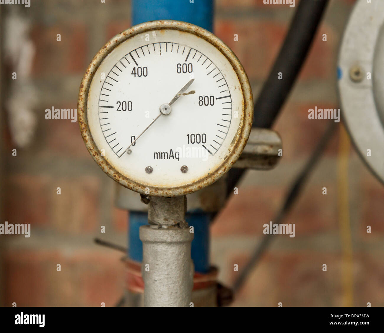 Rusty Pressure Gauge connected to pipes with brick wall behind Stock ...