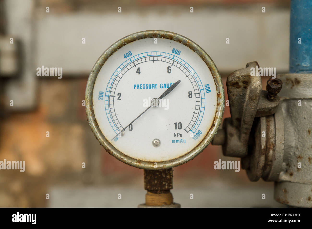 Rusty Pressure Gauge connected to pipes with brick wall behind Stock ...