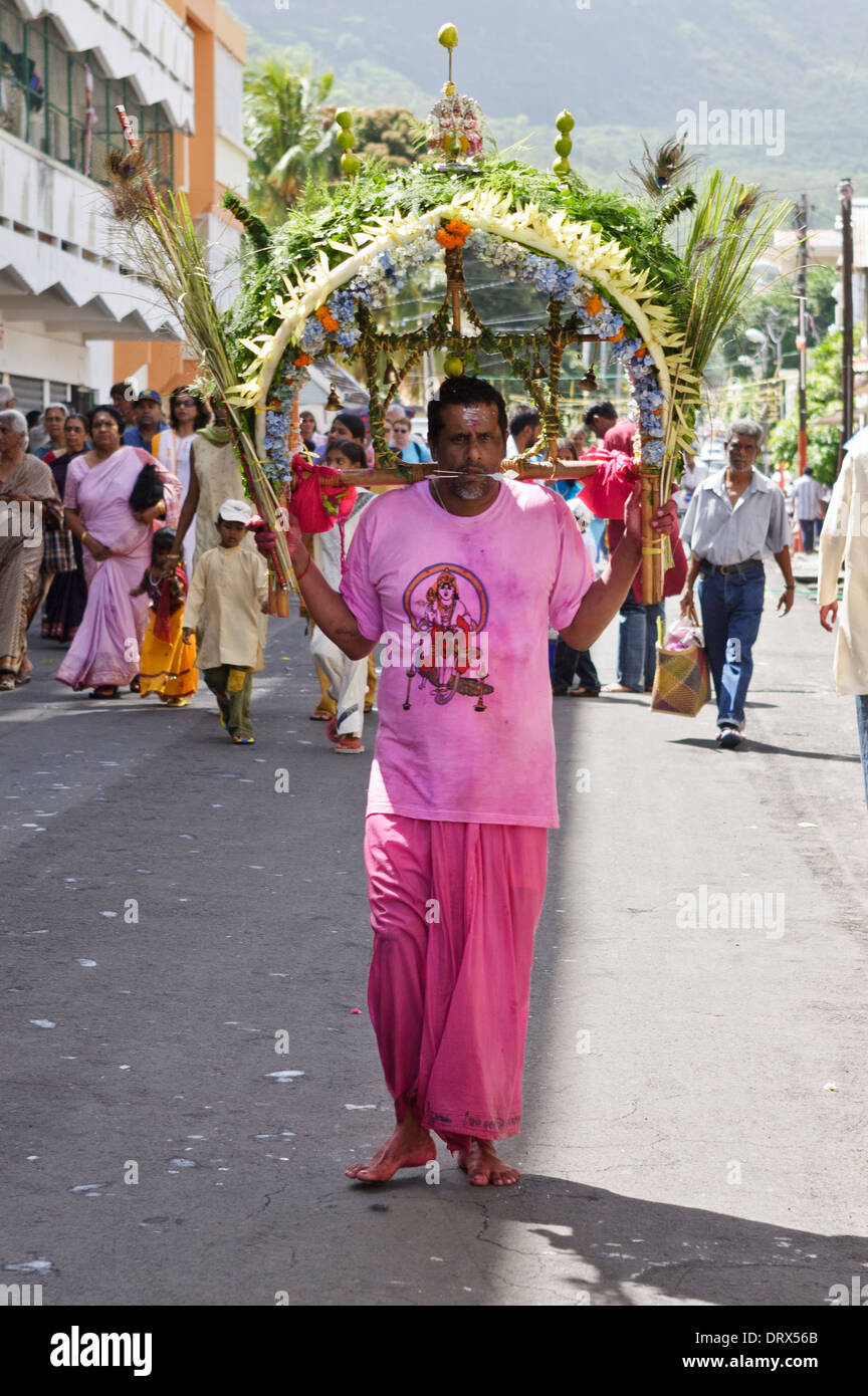 A devotee of Lord Muruga carrying the Cavadee with his cheeks and ...