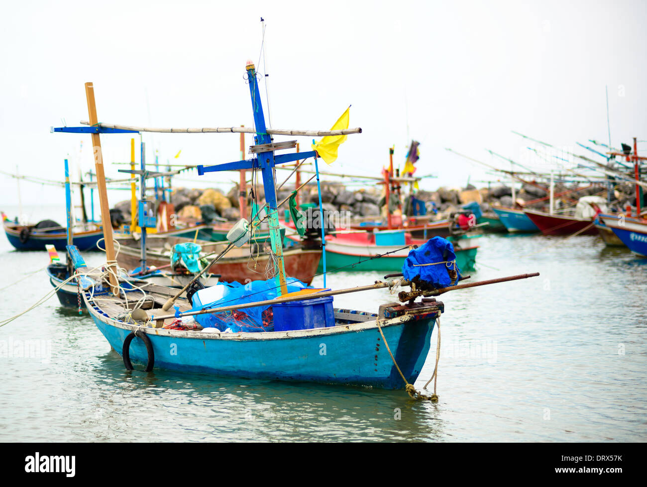 Beautiful and colorful Thai fishing boats docked by the ocean in Hua Hin, Thailand on an ...