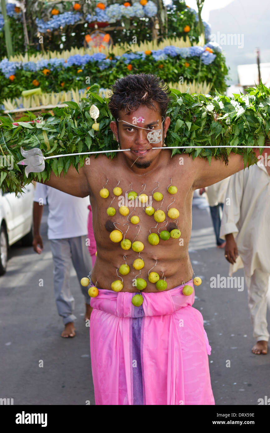 A devotee of Lord Muruga carrying the Cavadee with his cheeks and ...