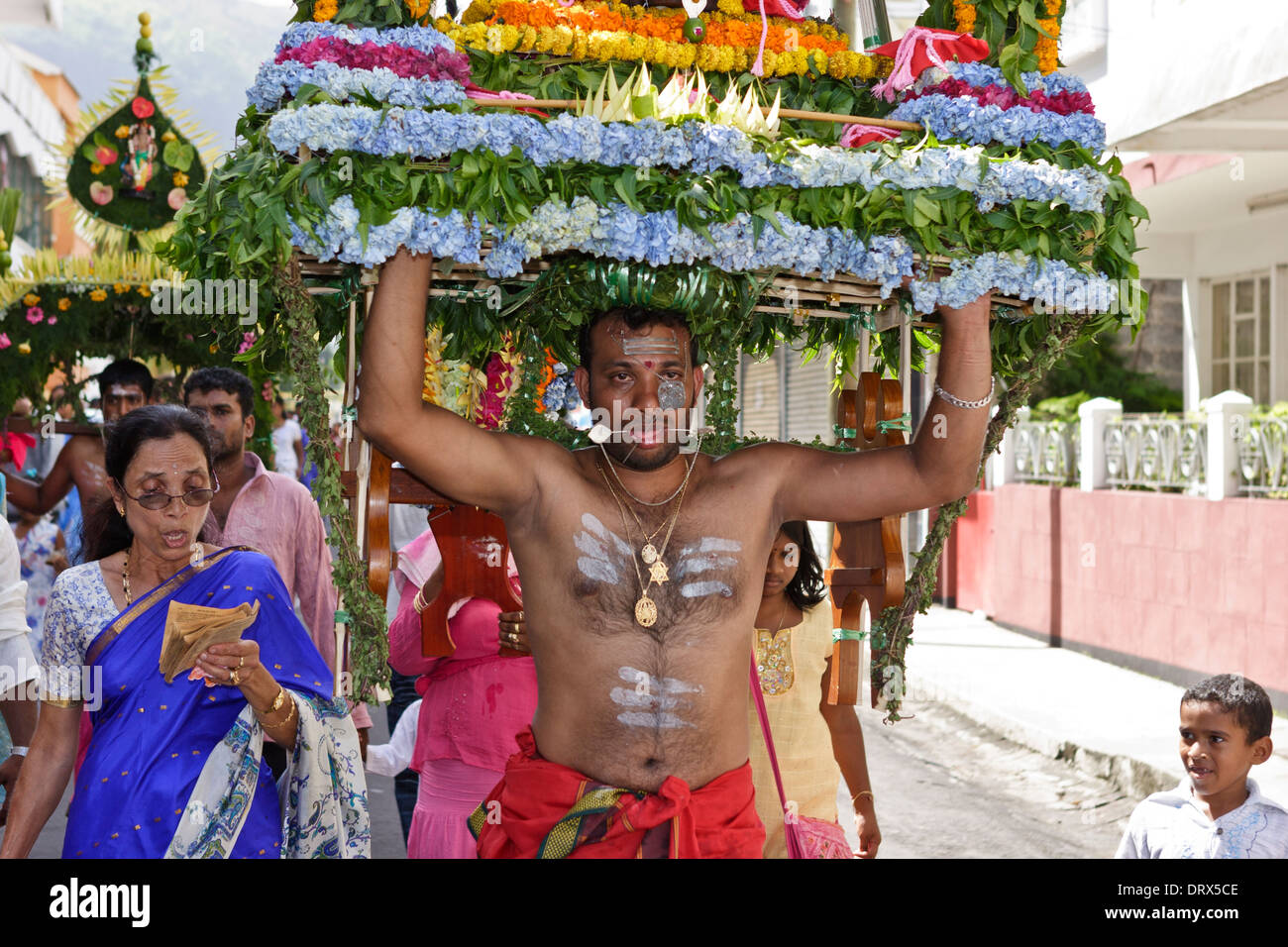 A Tamil devotee of Lord Muruga carrying the Cavadee accompanied by ...