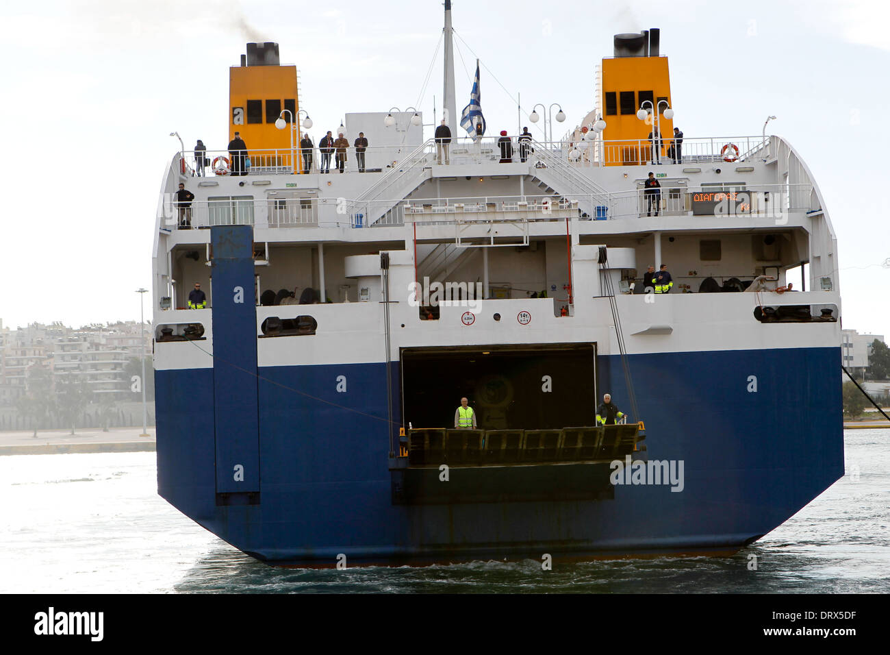 Ship crew guiding heavy duty mooring rope during docking procedure ...