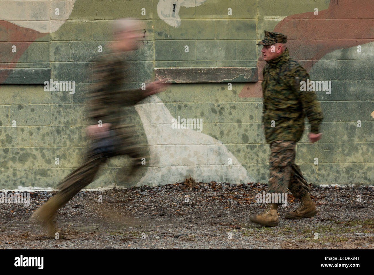 A US Marine runs at the command of a drill instructor during boot camp ...