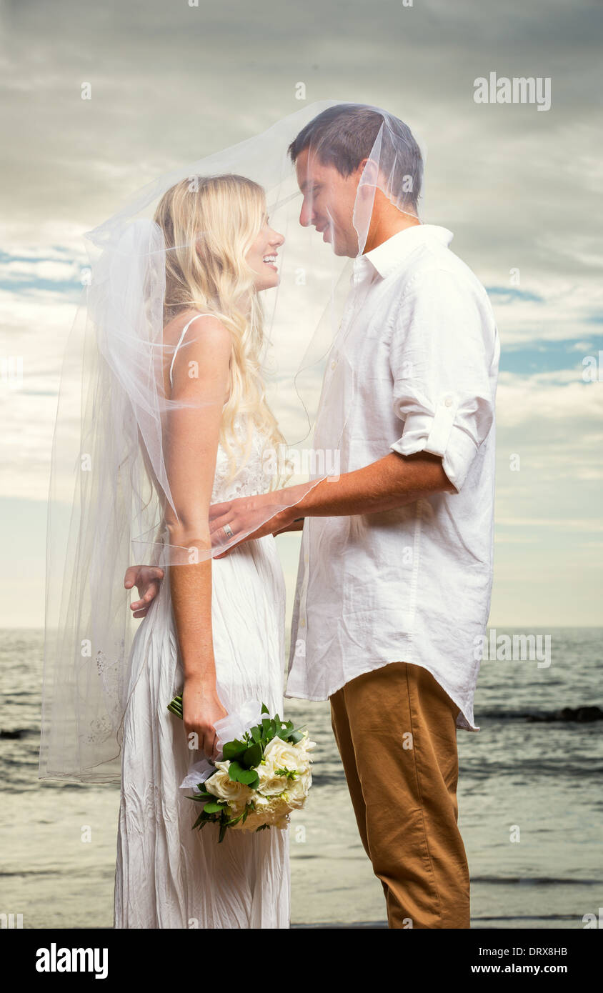 A married couple, bride and groom, at sunset on a beautiful tropical ...