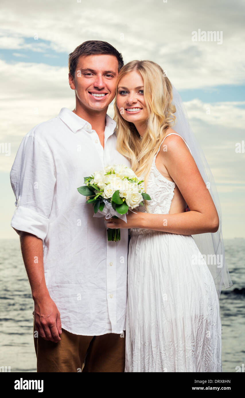A married couple, bride and groom, at sunset on a beautiful tropical ...