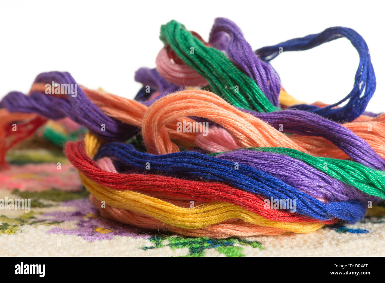 skeins of multicolored threads for embroidery - muline. on a white ...