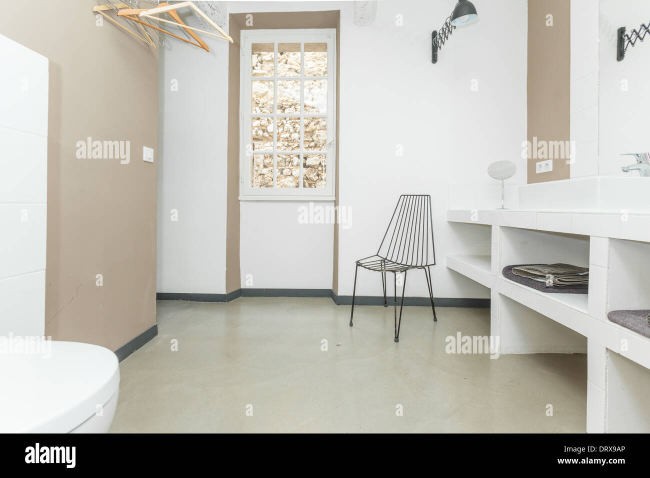 Big comfortable toilet room with chair and towel shelves Stock Photo ...