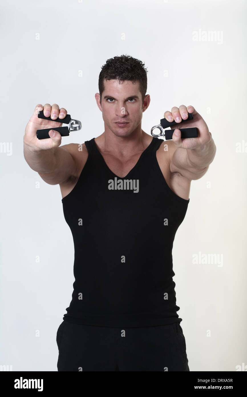 good looking male bodybuilder using hand gripper Stock Photo - Alamy