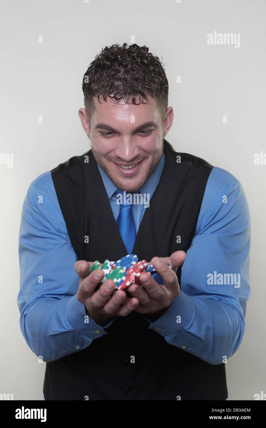 handsome man holding a lot of poker chips in two hands looking very ...
