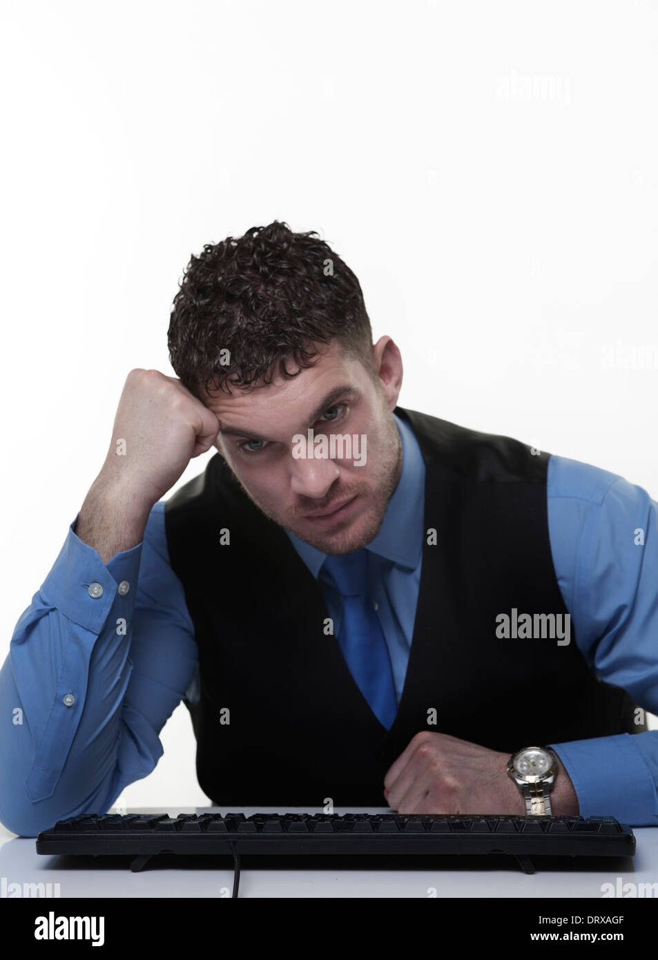 business man working at his desk not looking happy Stock Photo - Alamy