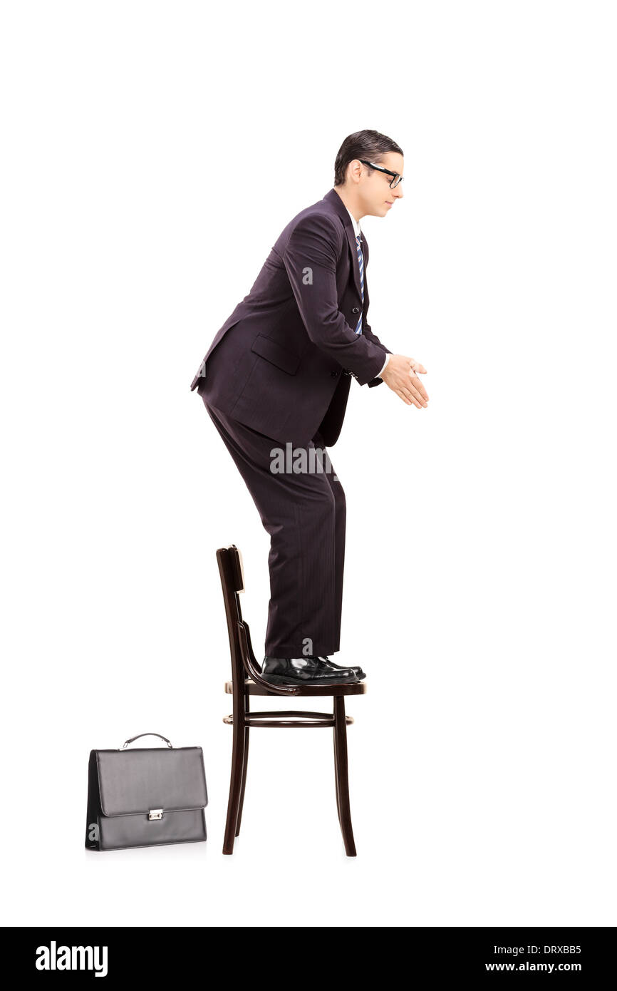 Full length portrait of a male businessman standing up on chair ready ...