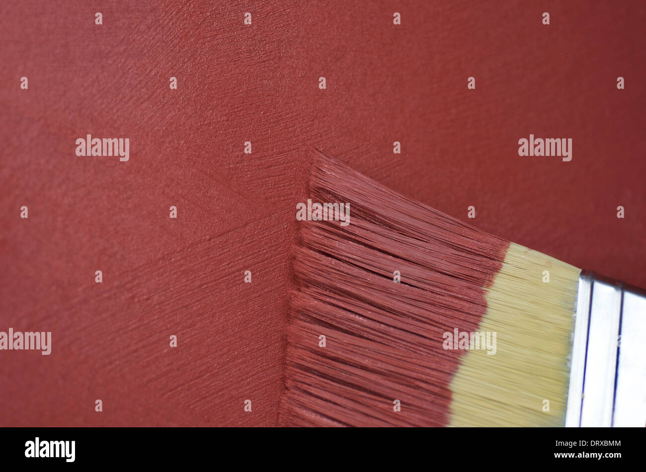 Paintbrush applying red textured paint to a wall Stock Photo - Alamy