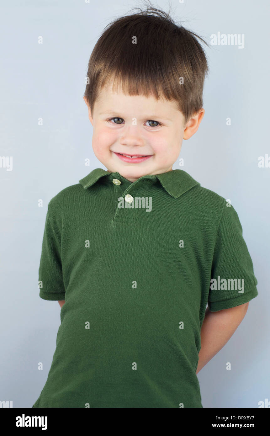 Cute little boy with hand behind his back and a big grin Stock Photo ...