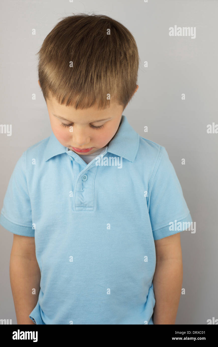 Sad little boy with head down Stock Photo - Alamy