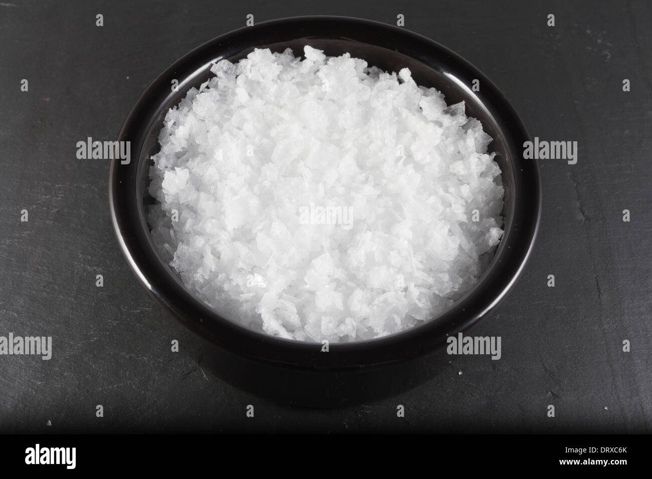 Sea salt flakes, in bowl . Welsh sea salt flakes on dark slate ...