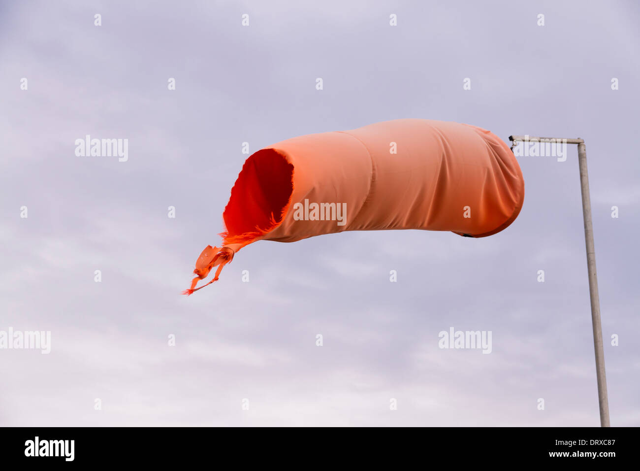 Wind sock (or conical textile tube) red and worn at one end against a ...