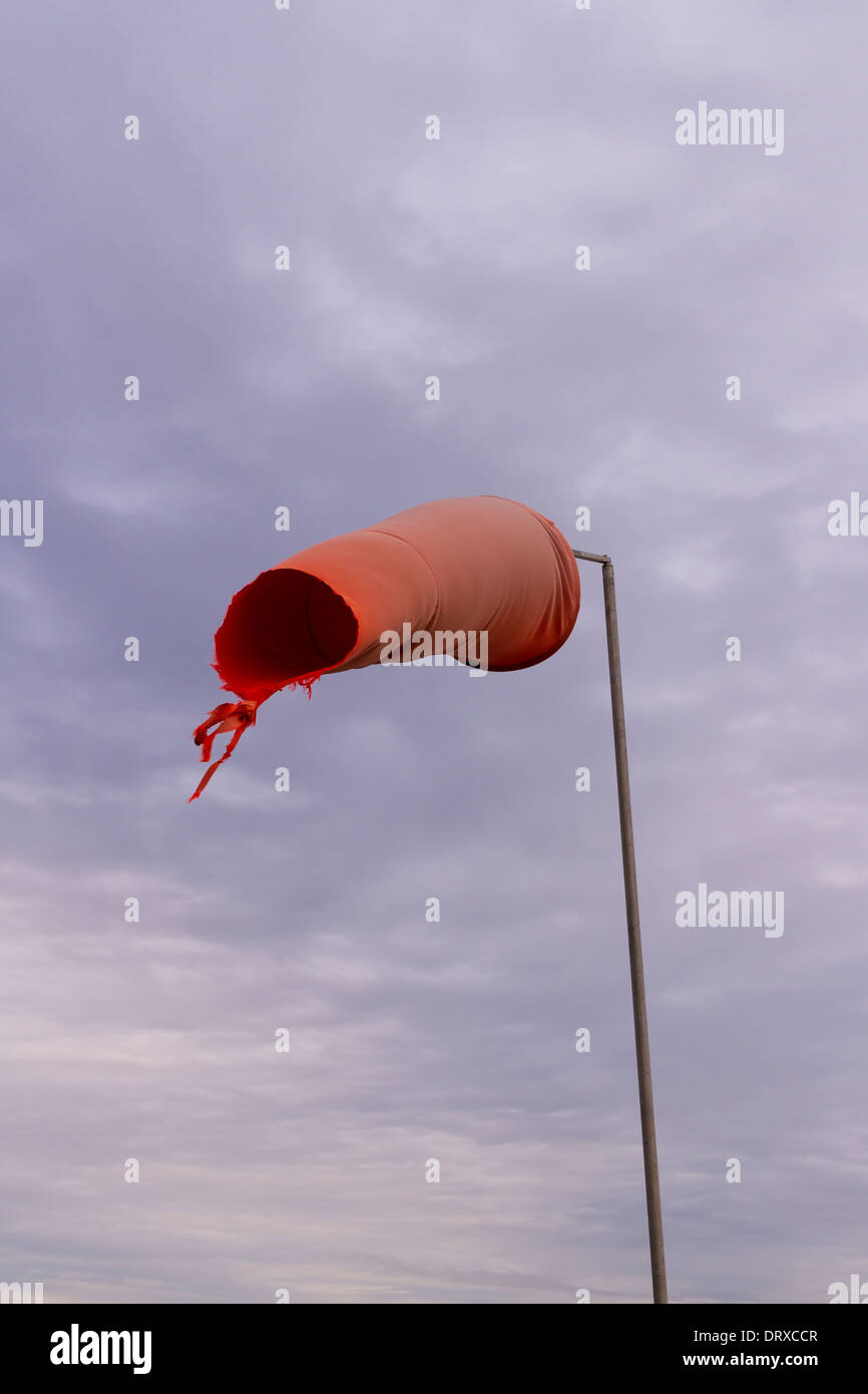 Wind sock (or conical textile tube) red and worn at one end against a ...