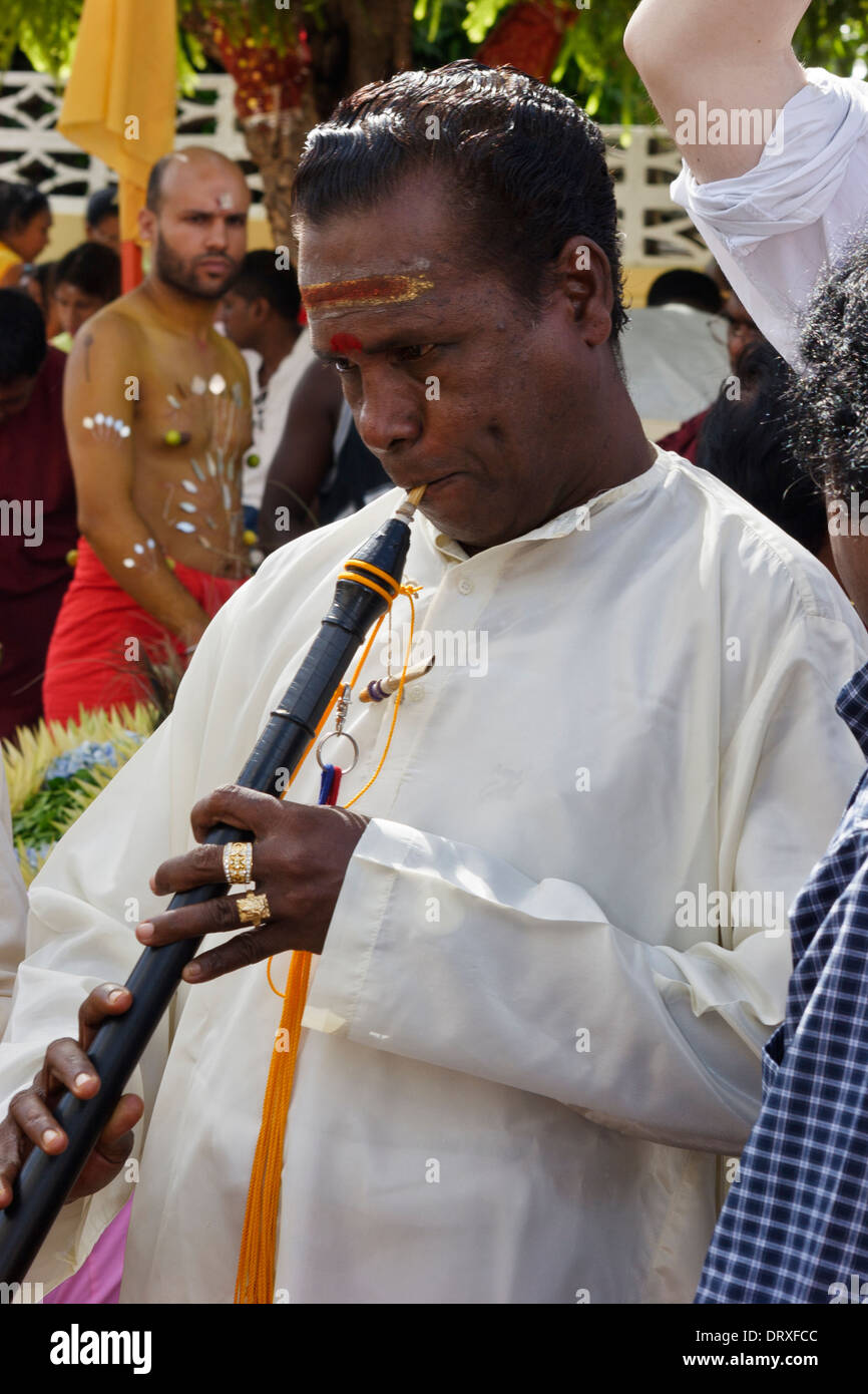A musician blowing a musical instrument during the Thaipoosam religious ...