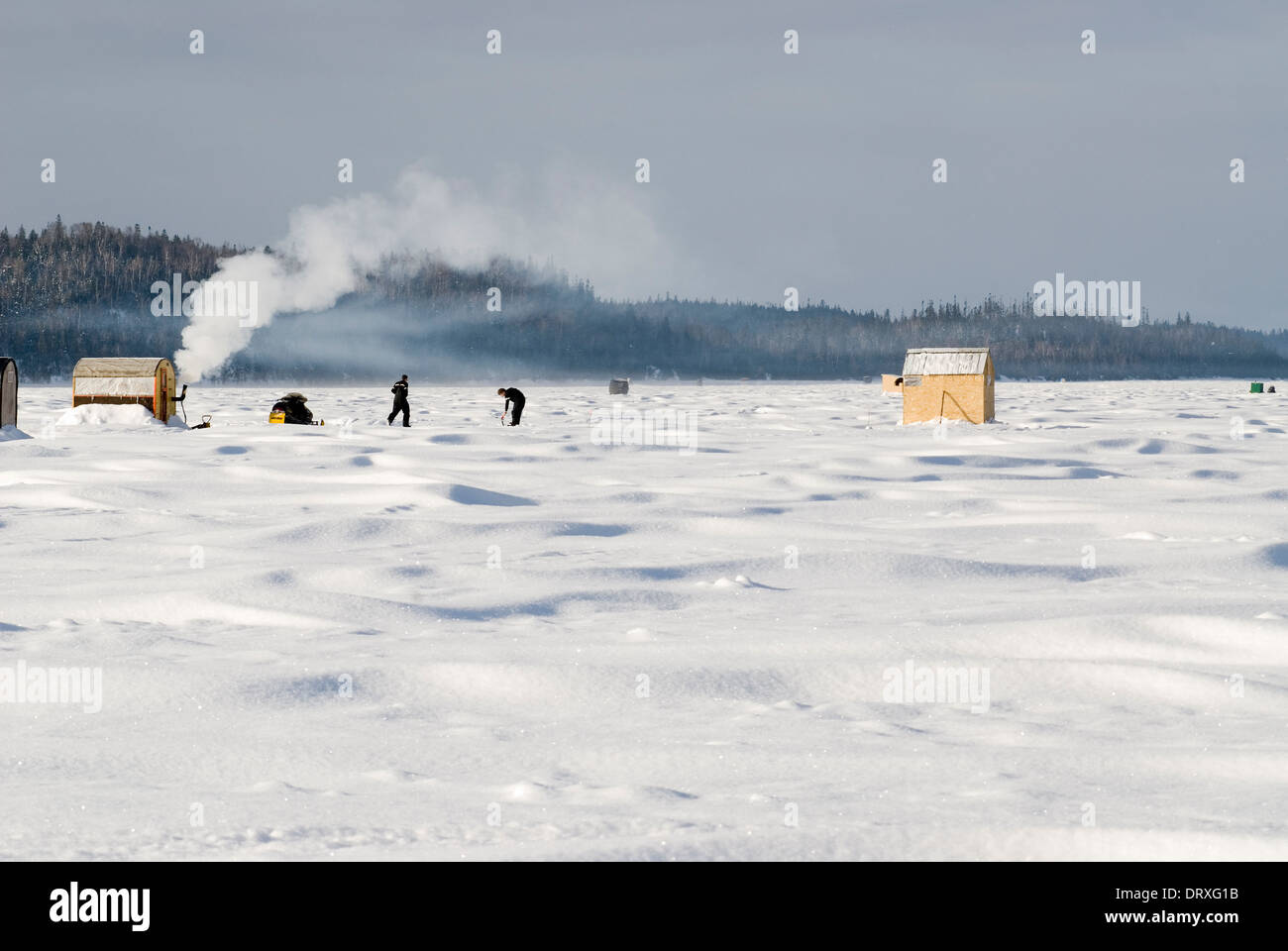 Ice fishermen fishing on a frozen lake near their hut Stock Photo - Alamy