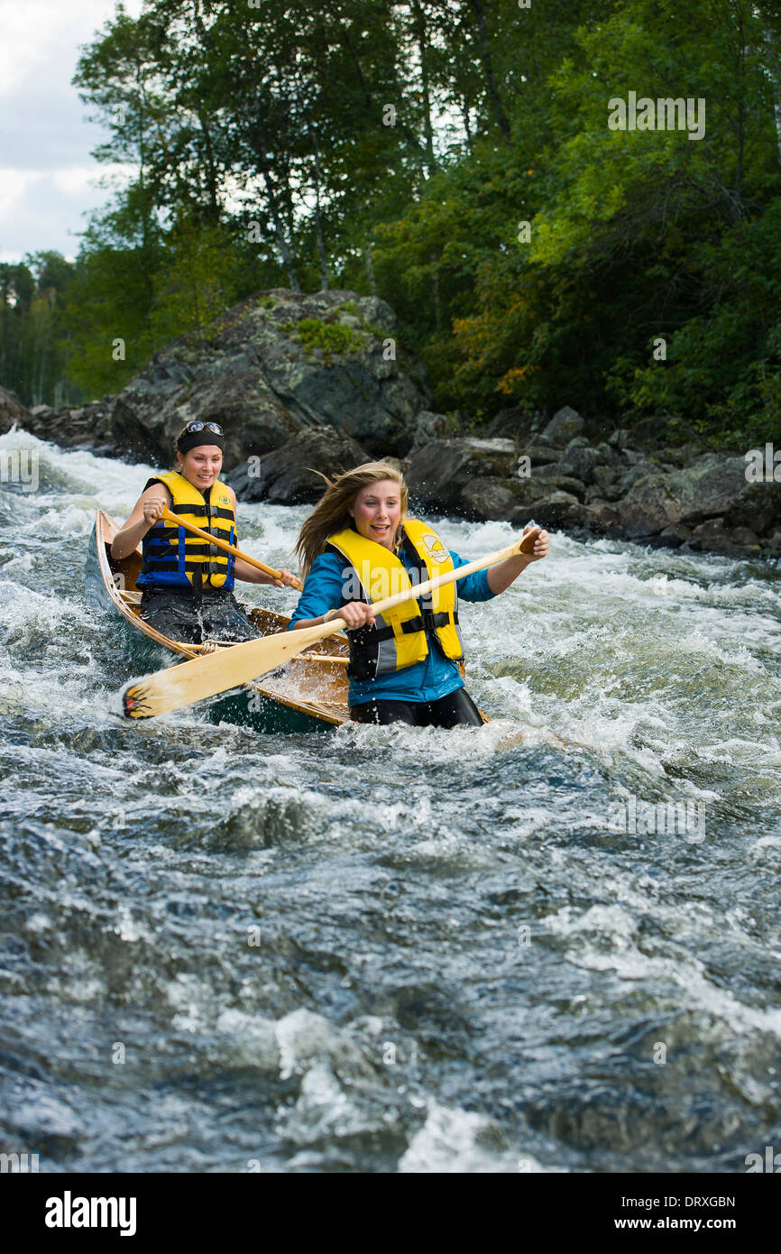 Canoeists paddle down river rapids Stock Photo - Alamy