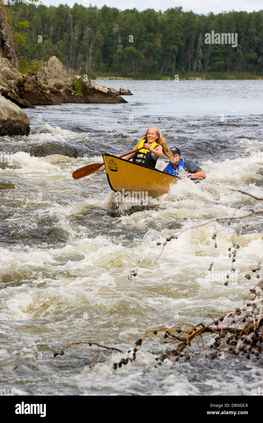 Canoeists paddle down river rapids Stock Photo - Alamy