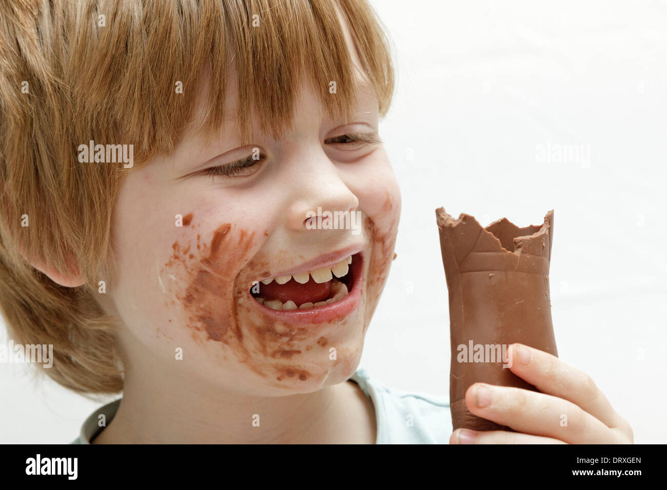 portrait of a happy young boy eating chocolate Stock Photo - Alamy