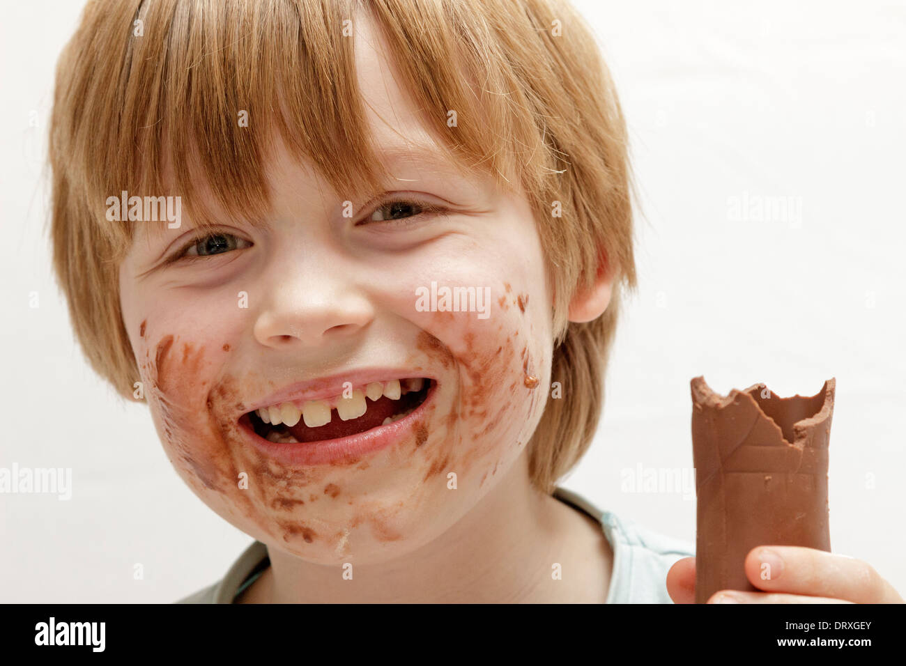portrait of a happy young boy eating chocolate Stock Photo - Alamy