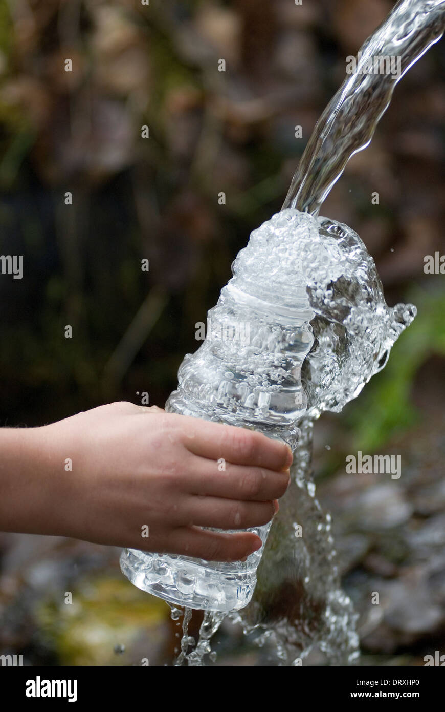 Filling a water bottle with natural spring water Stock Photo - Alamy