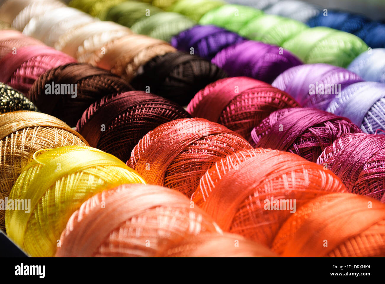 Different color threads on rows in the store Stock Photo - Alamy