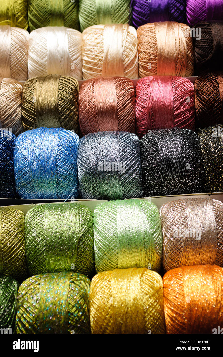 Different color threads on rows in the store Stock Photo - Alamy