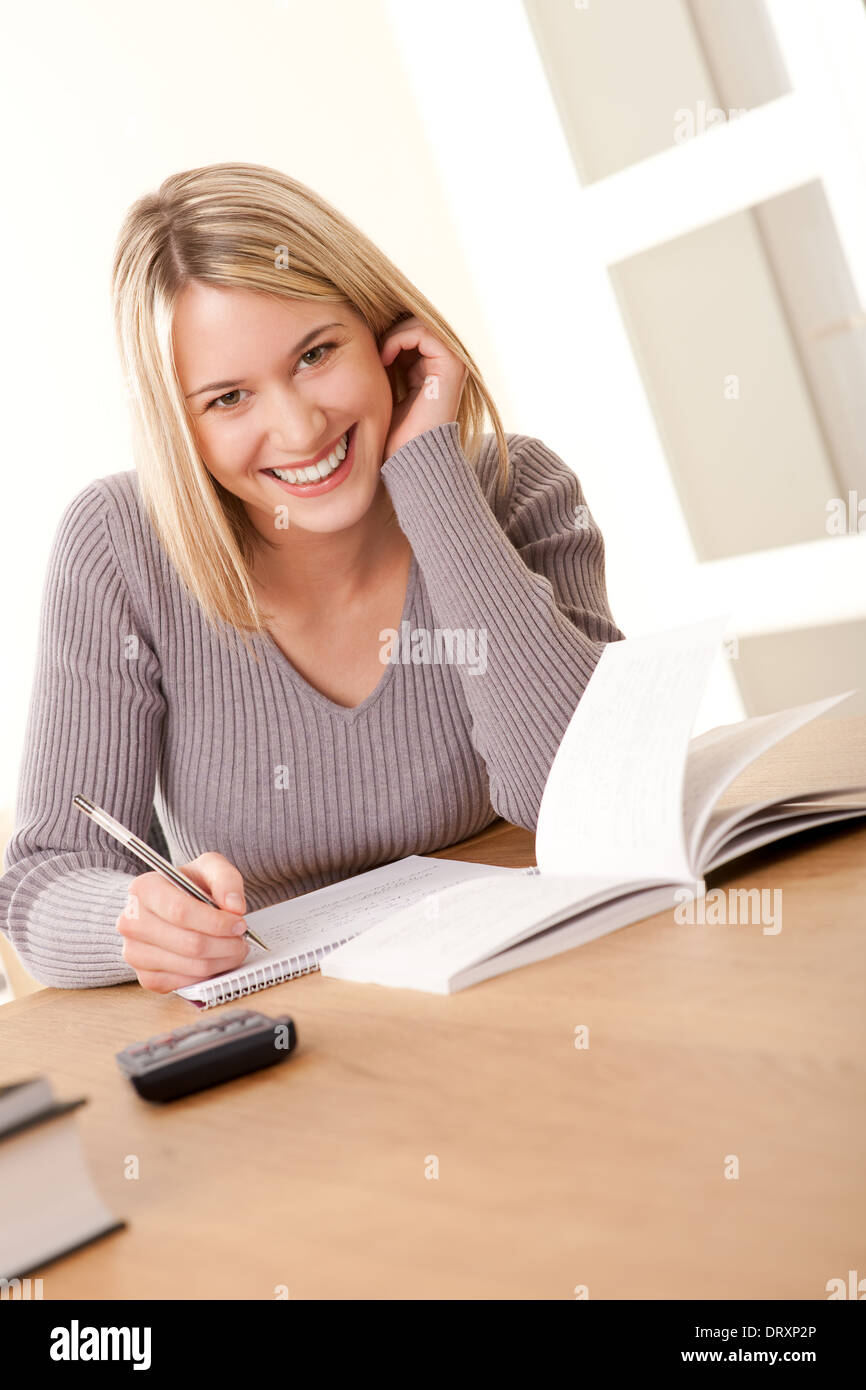Student series - Blond girl studying home Stock Photo - Alamy